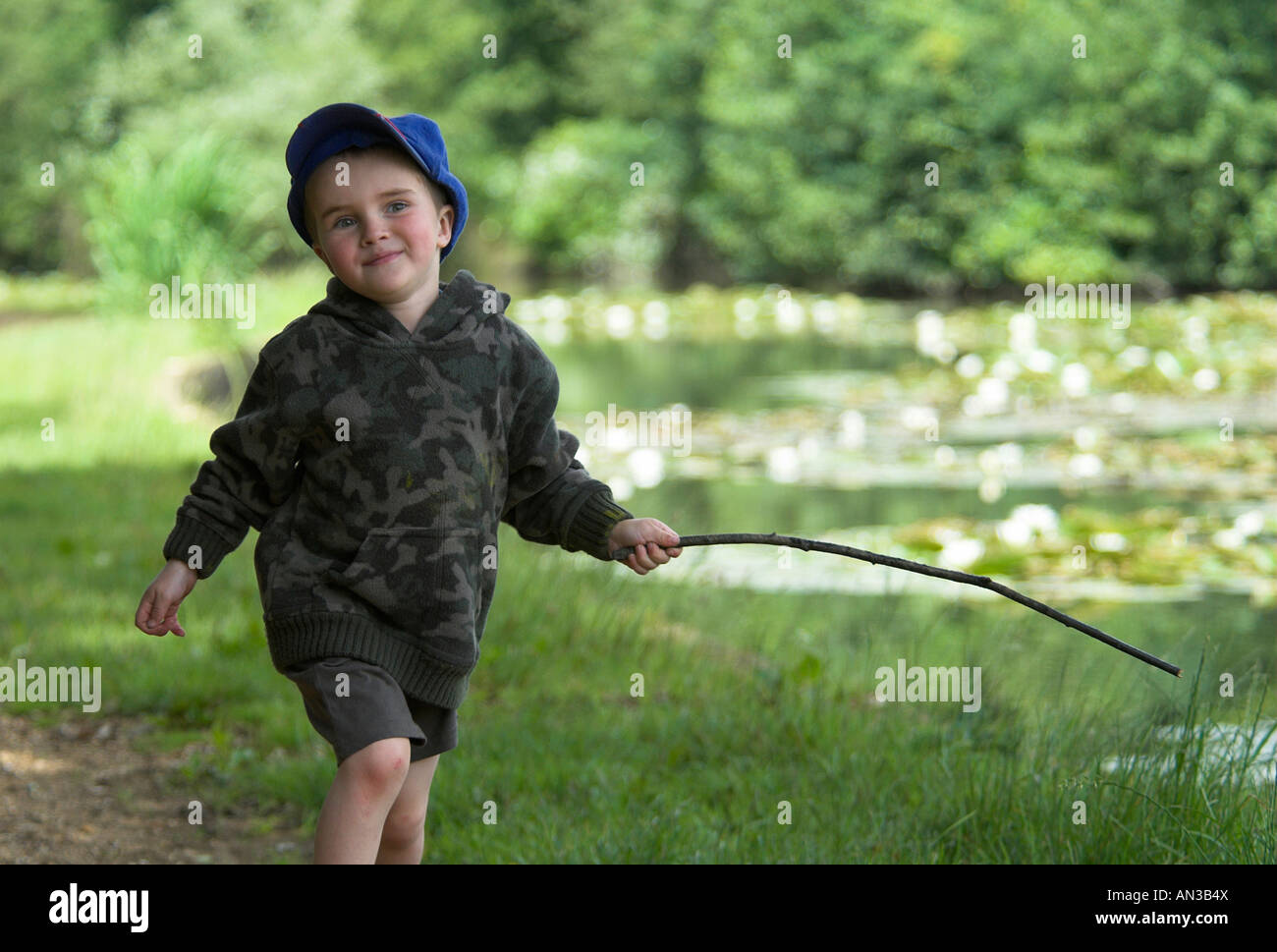 Small Boy Carrying a Stick Stock Photo - Alamy