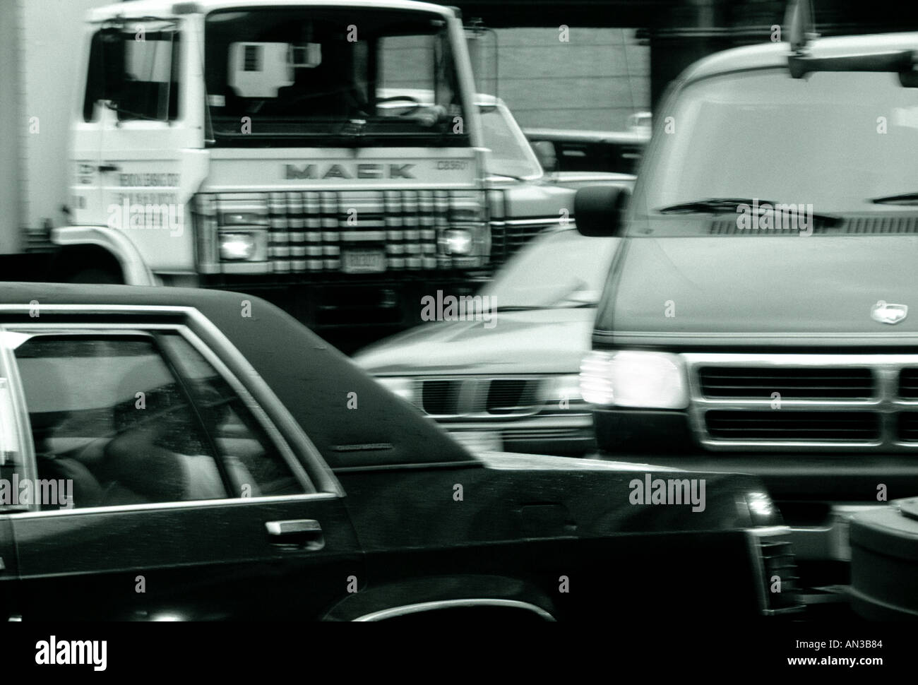 Black and white blurred 1980's image of traffic rushing in city streets ...