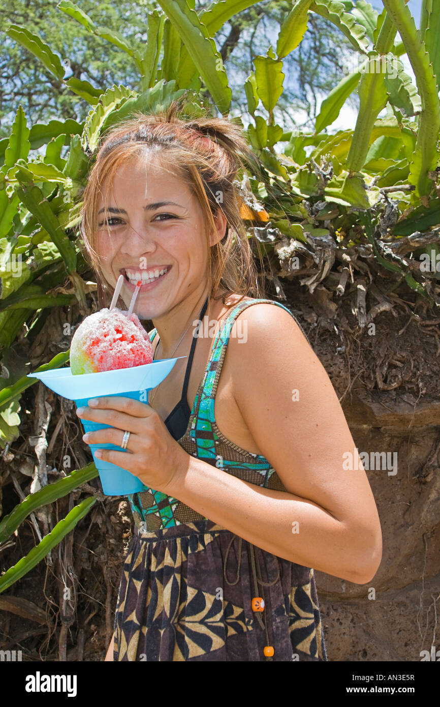 Young woman drinks shave ice a favorite local mix of fruit syrups and ...