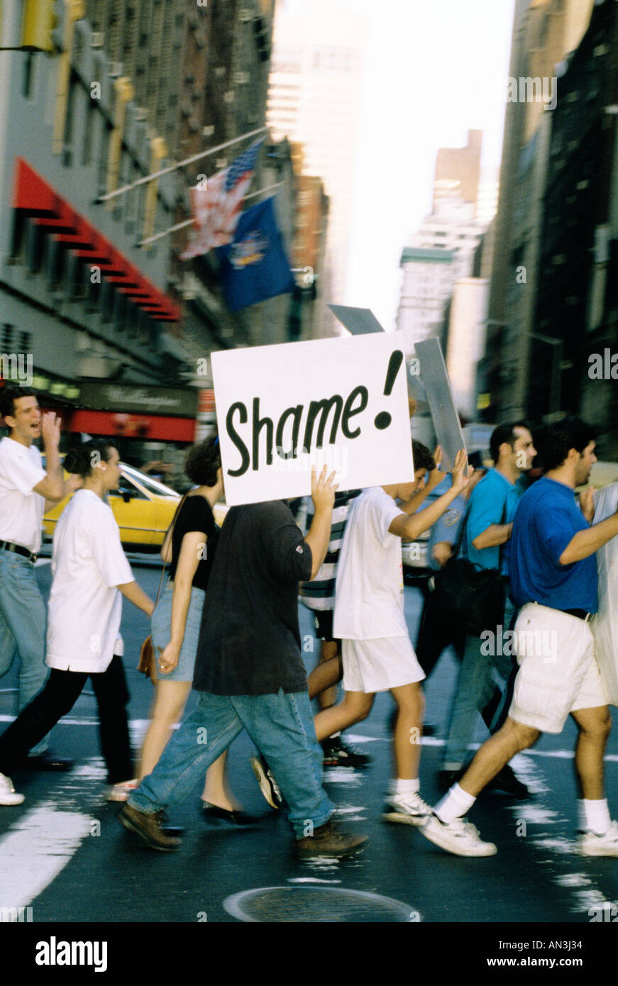 PROTESTERS CROSSING STREET HOLDING SIGN SHAME Stock Photo - Alamy