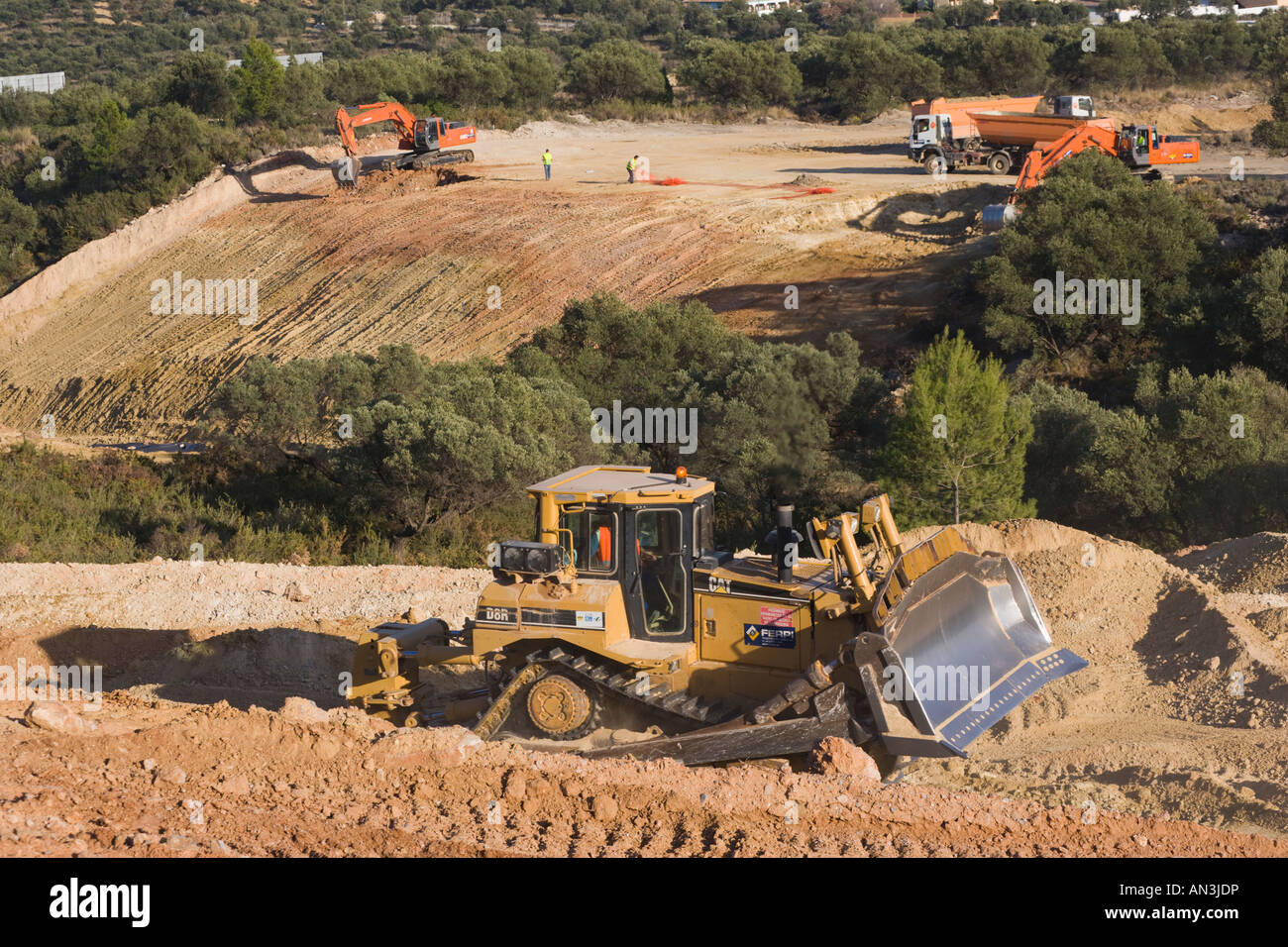 Bulldozer mechanical digger and tip trucks at work in Spain road making ...