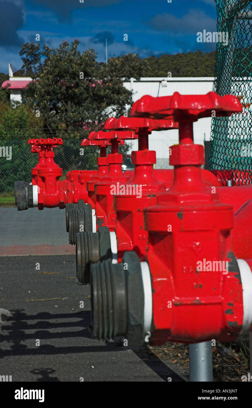 Red fire hydrants at industrial site Focus is on the third hydrant from ...