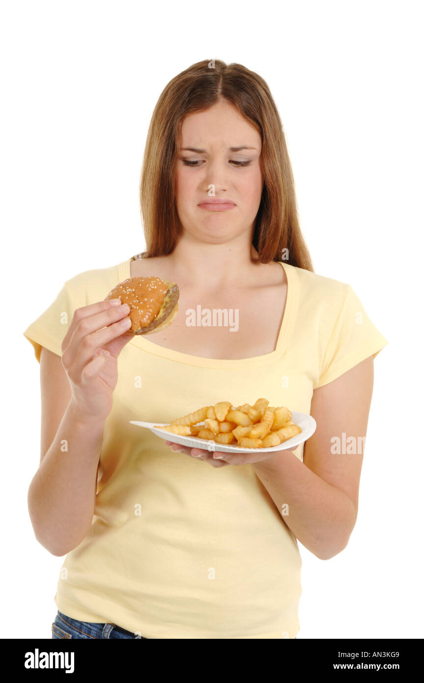 a teenage girl looking in a disgusted way at a hamburger and chips ...