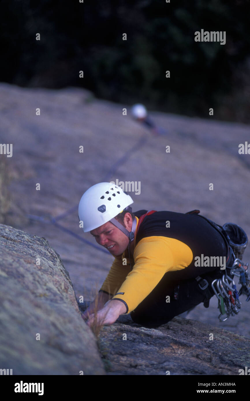Man climbing a steep rock face Stock Photo - Alamy