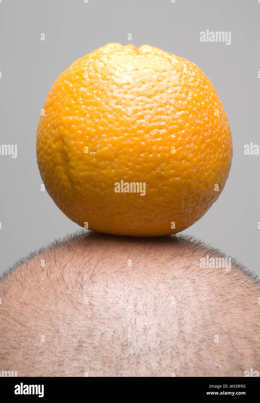 Orange on a bald head on white background Stock Photo - Alamy