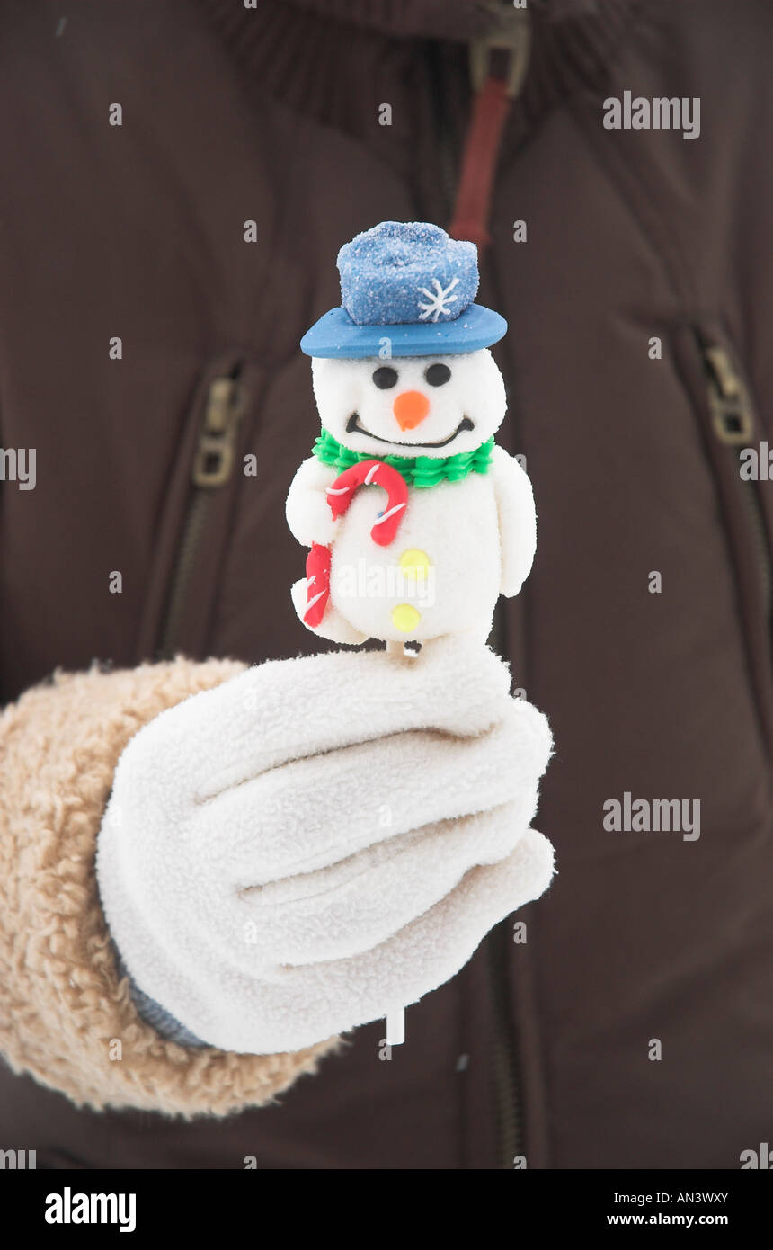 Gloved hand holding marshmallow snowman Stock Photo - Alamy