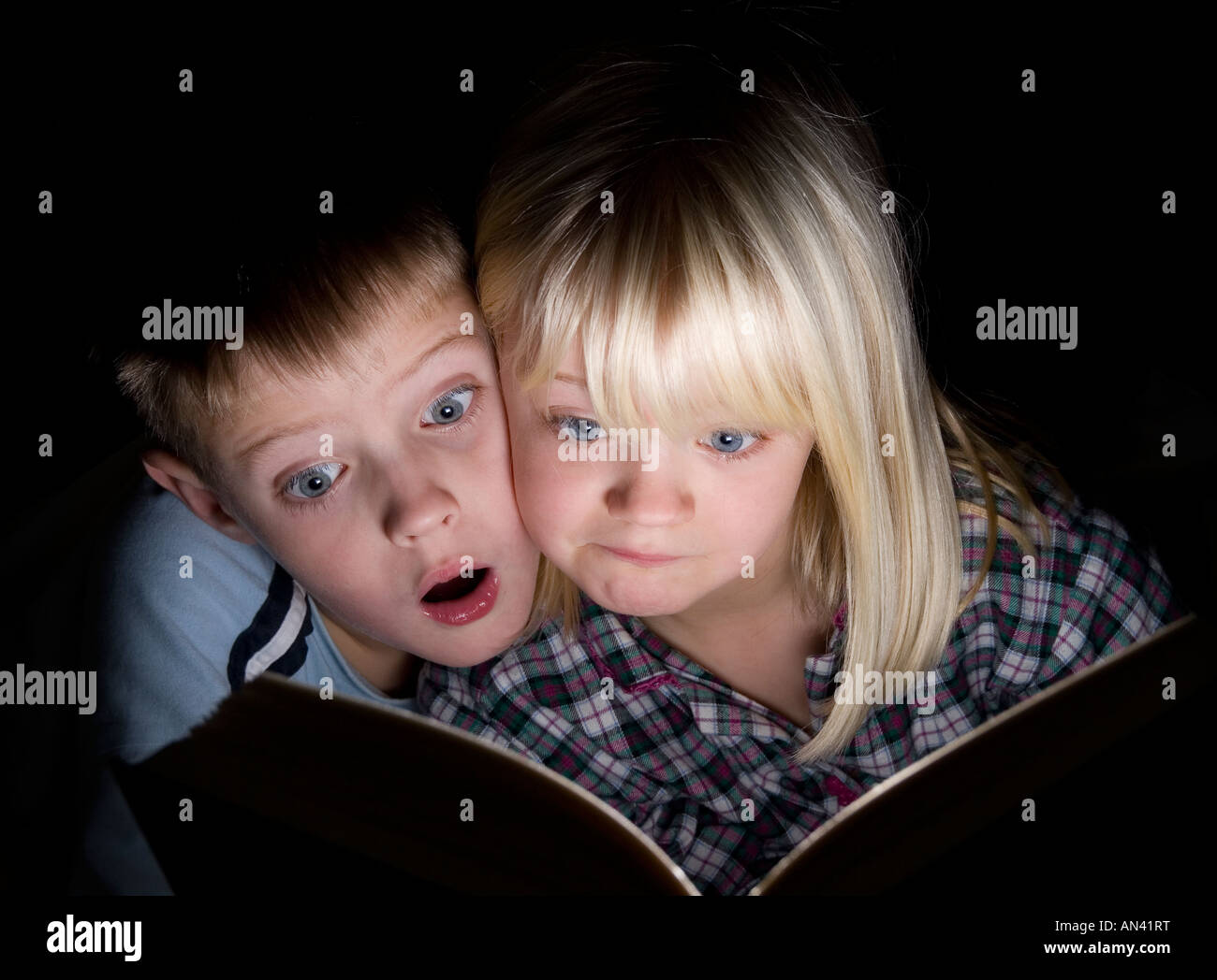 children reading book by torchlight at bedtime Stock Photo - Alamy