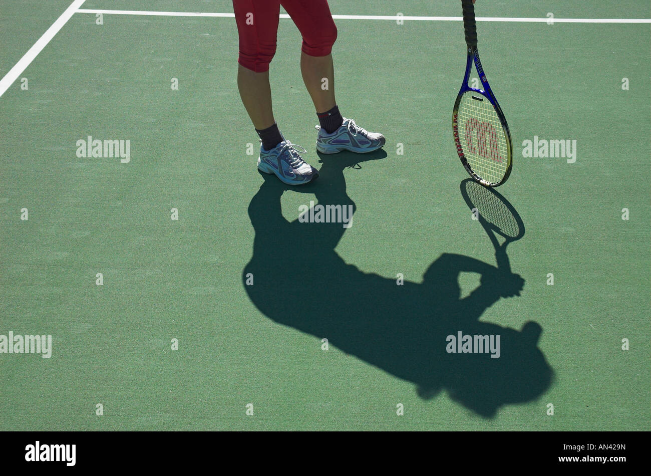 Tennis player leaning on their racquet with defeated body language ...