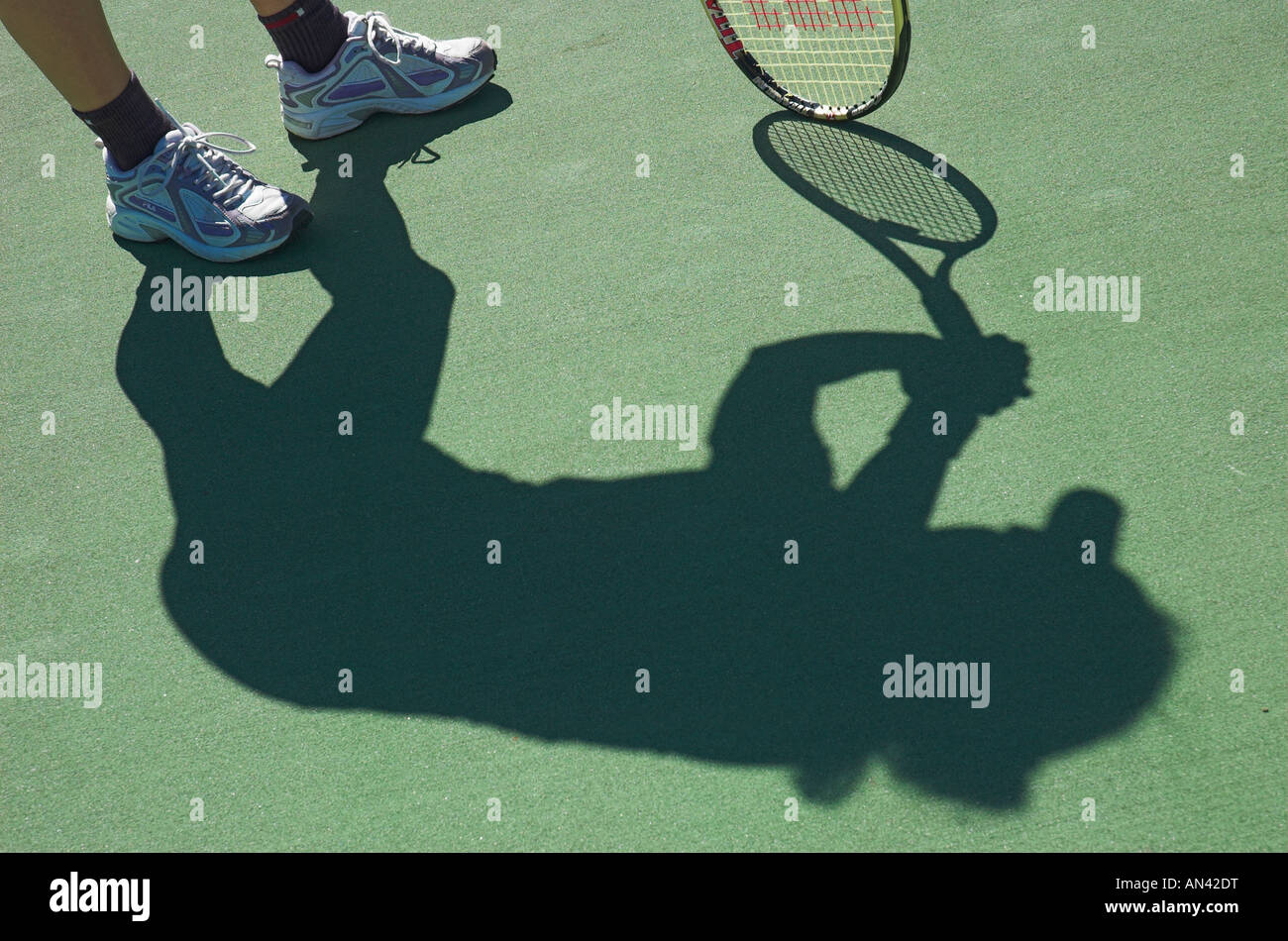 Tennis player leaning on their racquet with defeated body language ...