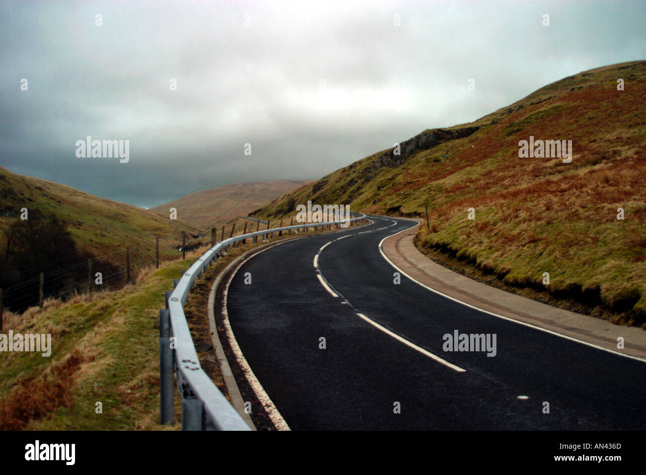 Hilltop road winding into distance Stock Photo - Alamy
