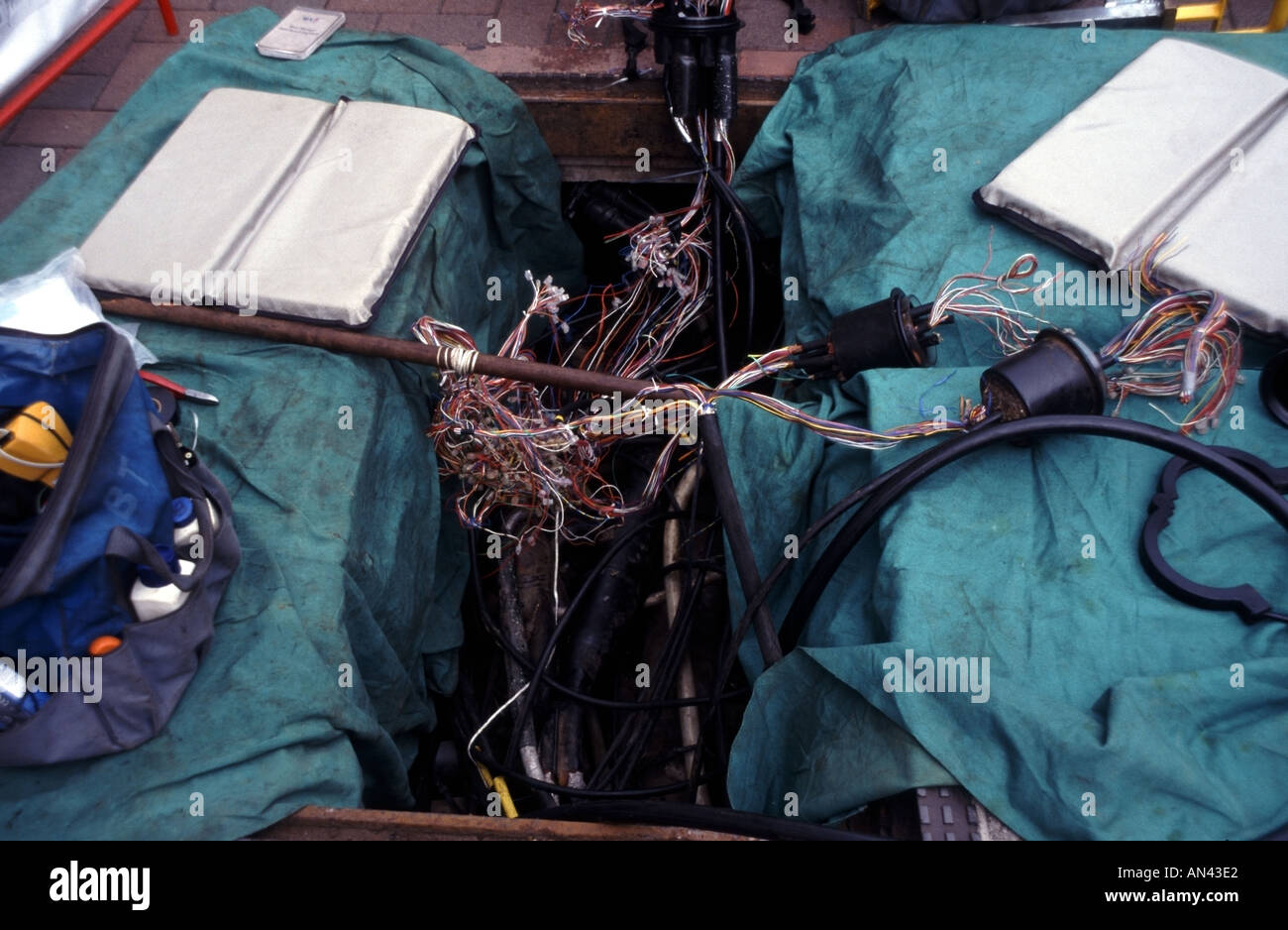 Protected open British Telecom cable manhole in pavement with exposed ...