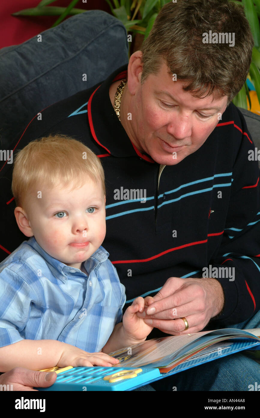 Baby Boy Reading With Father Stock Photo - Alamy