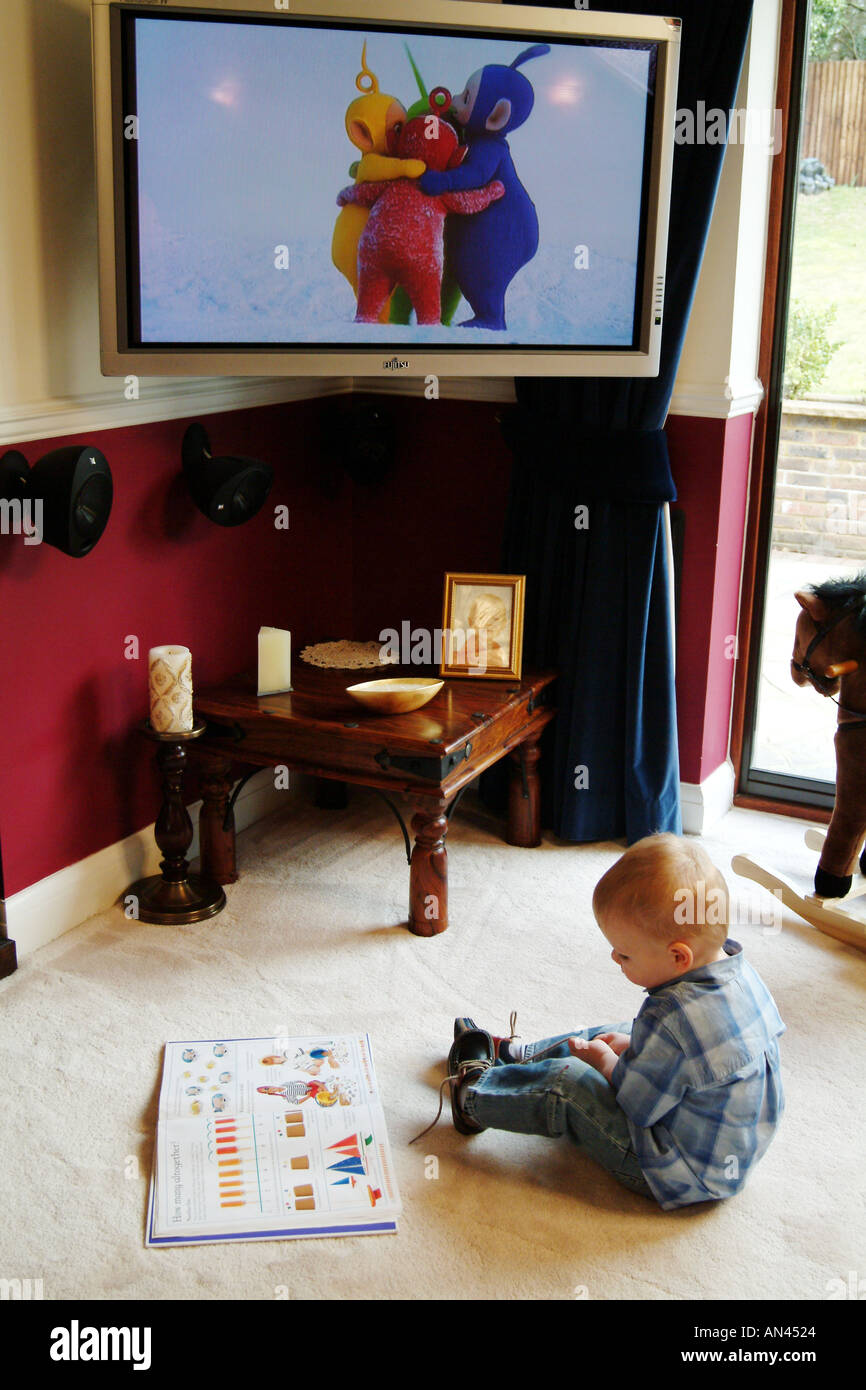Child watching television set Little boy sitting.Reading and watching a ...