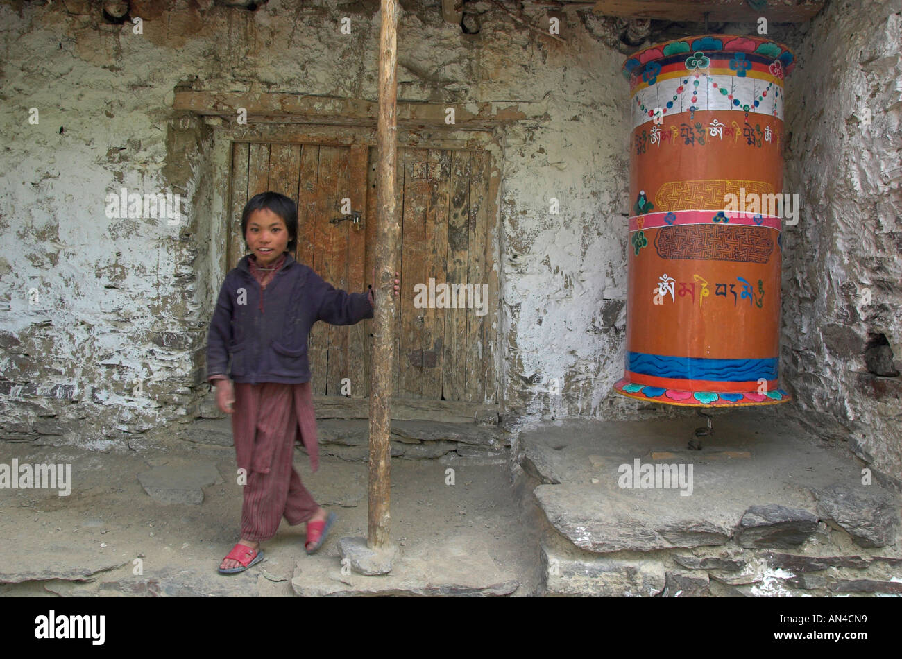 Girl by prayer wheel Ichar Zanskar India Stock Photo - Alamy