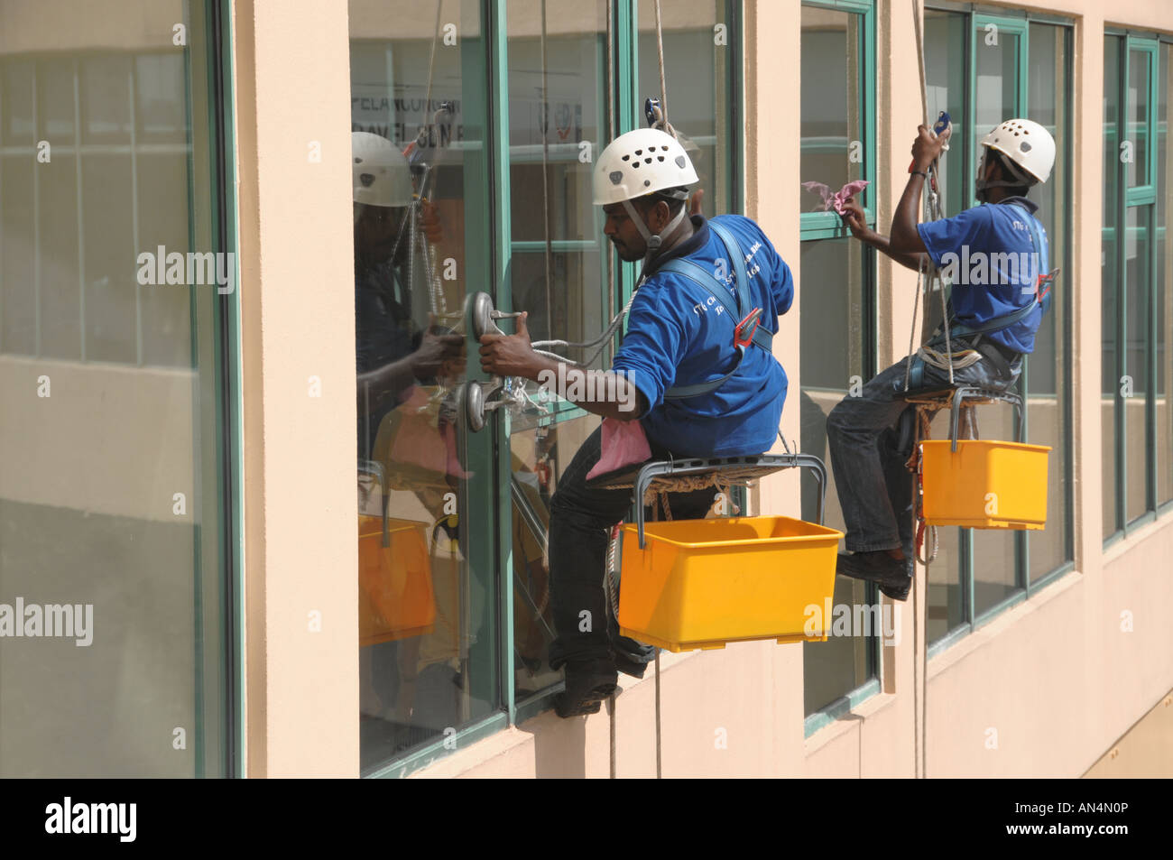 Two window cleaners cleaning the glass of a high rise building, Sunway ...