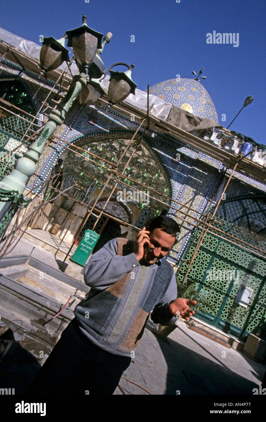 A man speaks on his mobile phone in front of a mosque undergoing ...