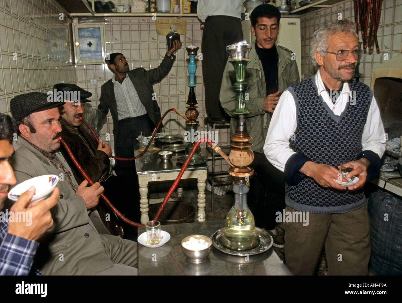 Customers drinking tea and smoking hookah in tea house, Tehran, Iran ...