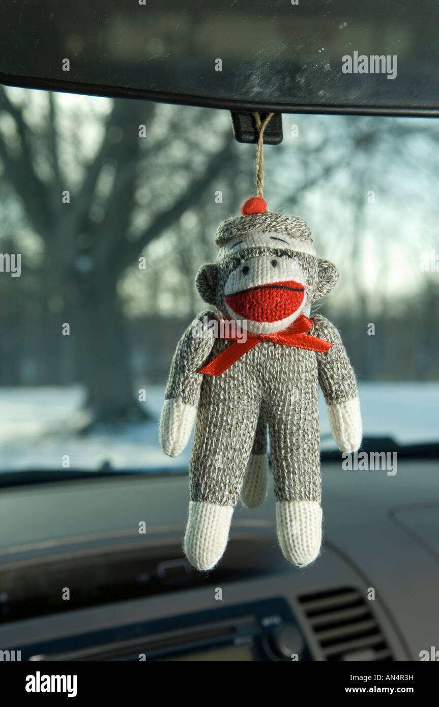 Sock monkey hanging from a rear view mirror Stock Photo - Alamy