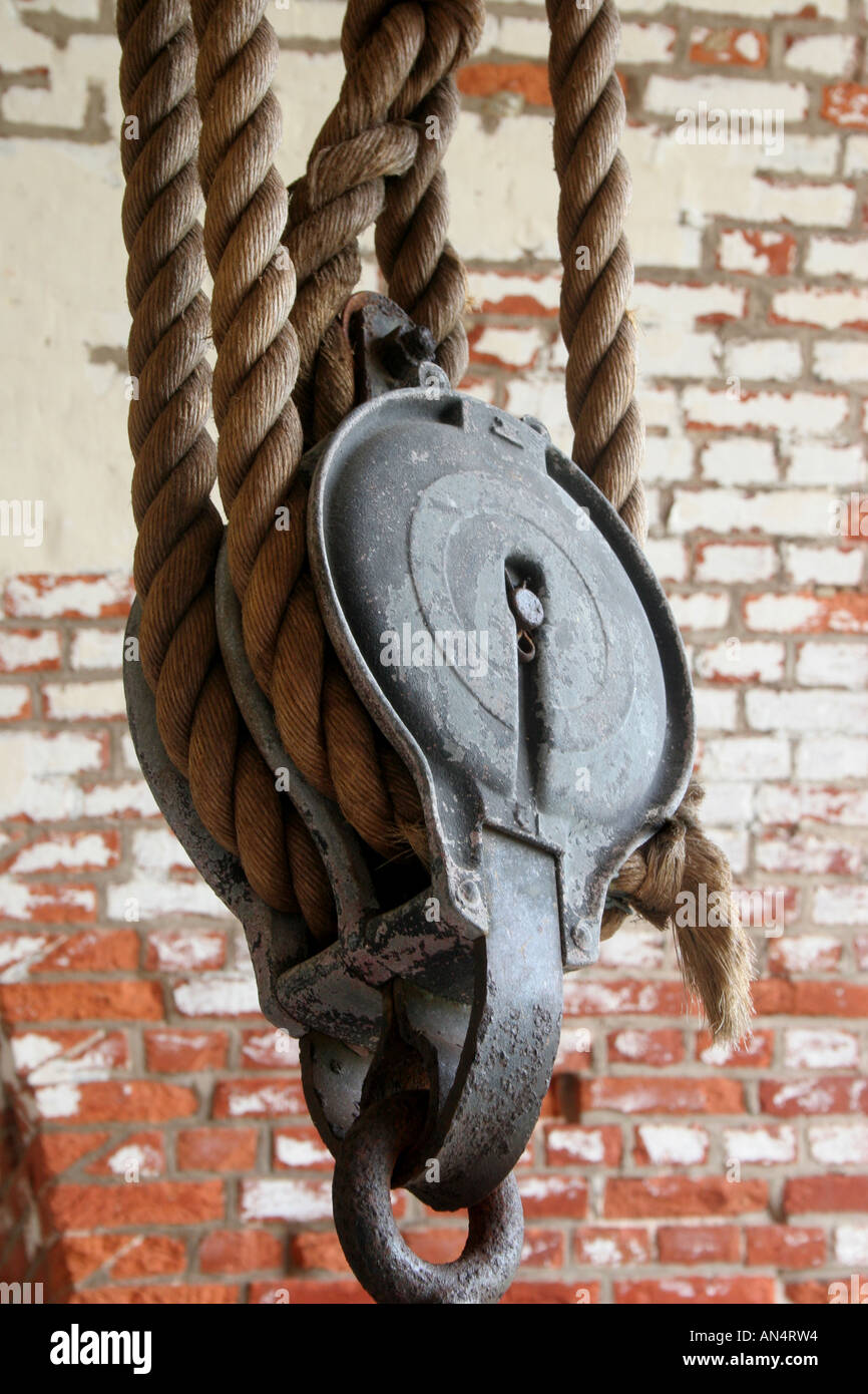 Tackle with rope to lift and a brick background Stock Photo - Alamy