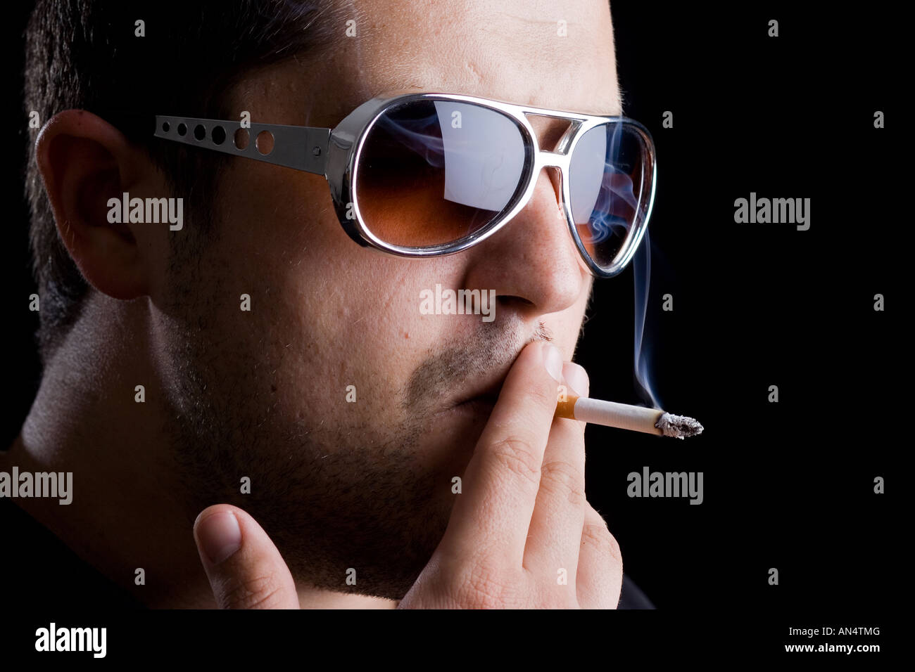 Handsome model smoking a cigarette Stock Photo - Alamy