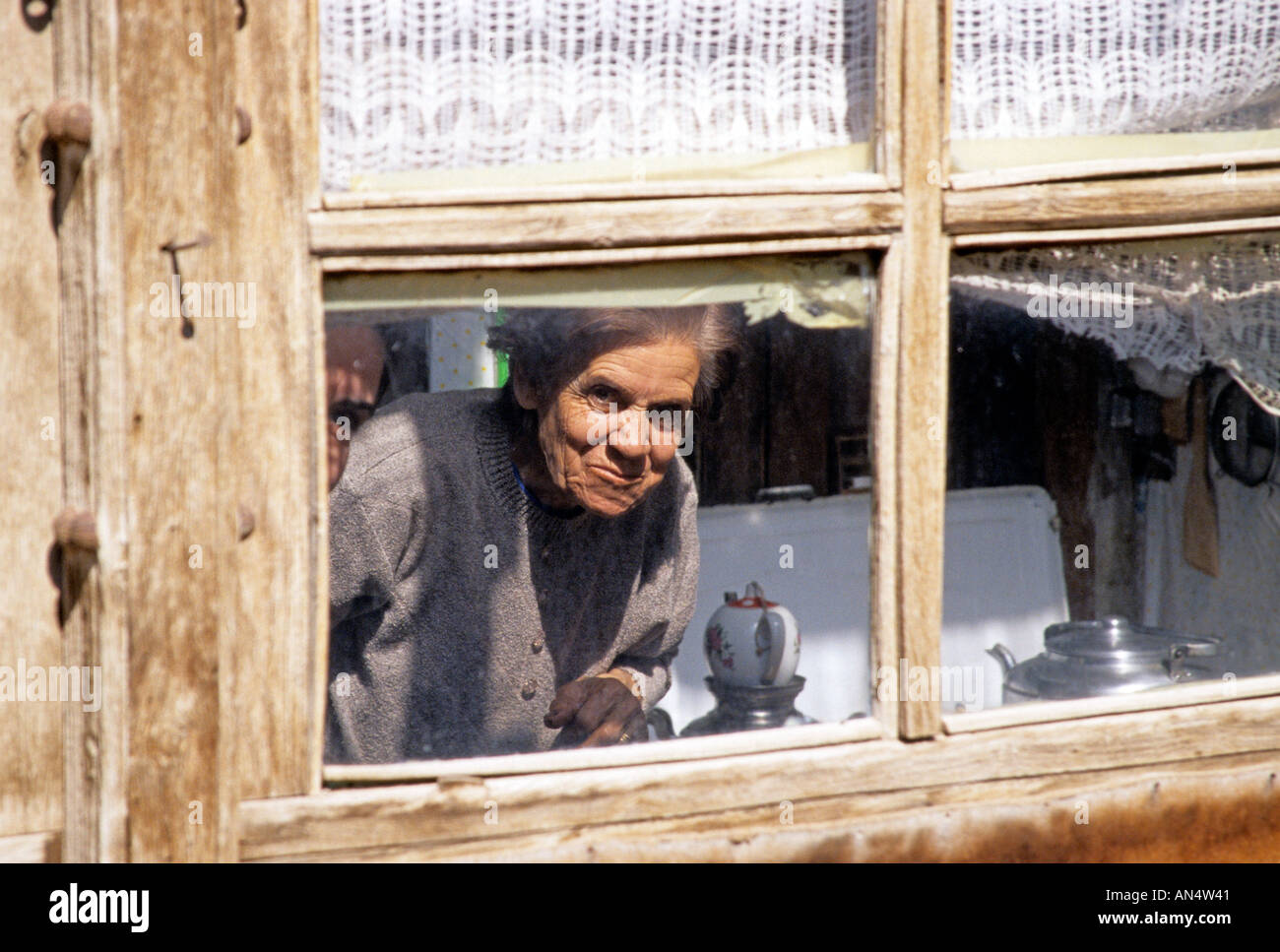 Senior couple residents peering through window, Armenian Quarters ...