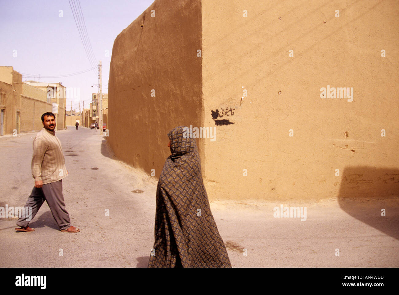 People walking along suburban street with traditional building, Iran ...