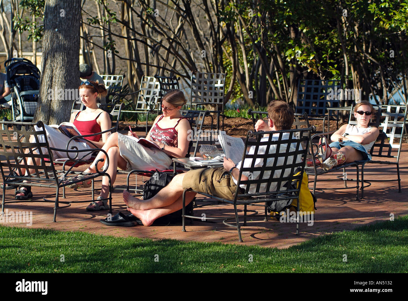 People sitting and reading newspaper in a park Stock Photo - Alamy