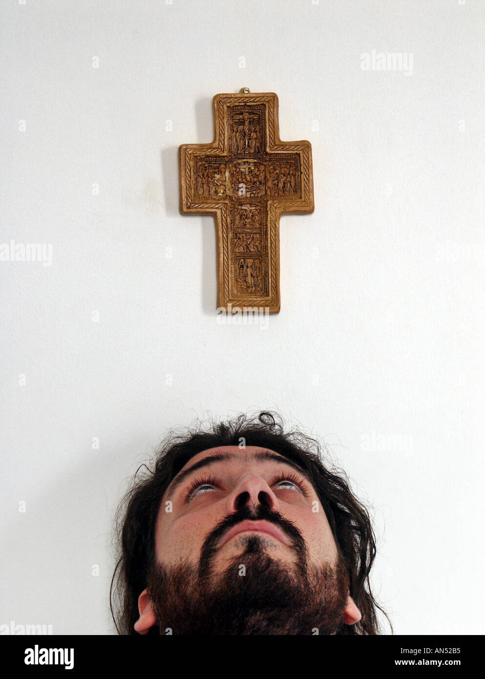 Man looking upwards at cross on the wall Stock Photo - Alamy