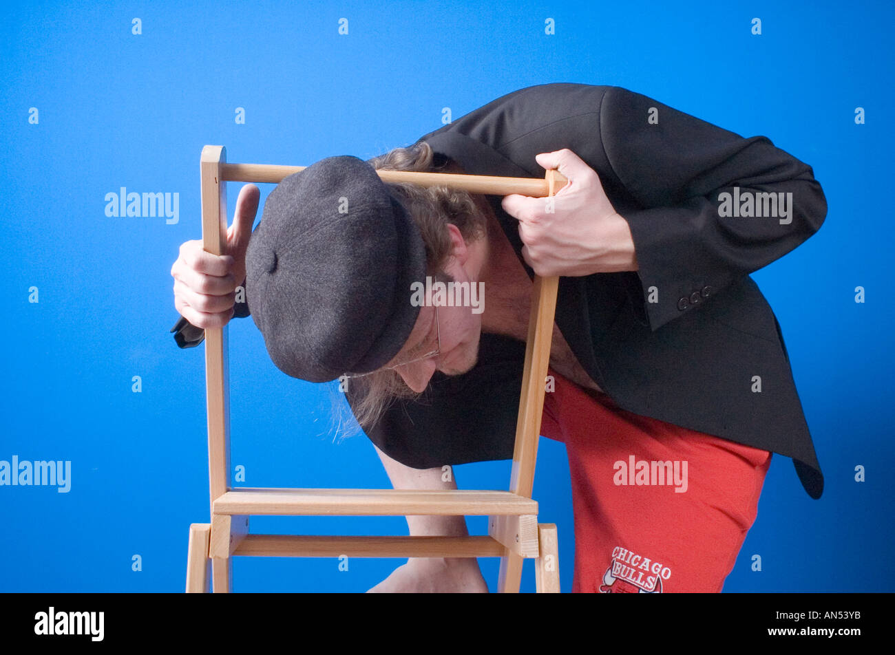 man sticking his head through ladder Stock Photo - Alamy
