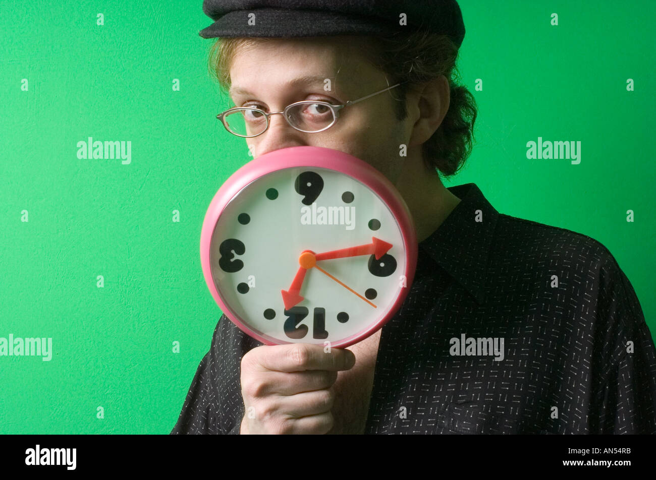 man hiding behind watch Stock Photo - Alamy