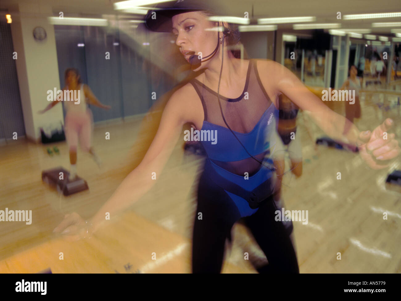 An aerobics instructor and her class go through the movements during a ...