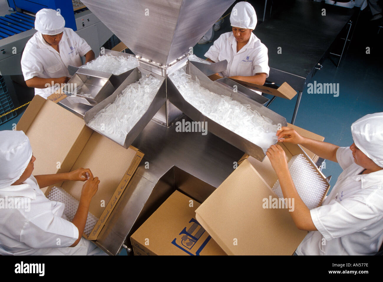 Female workers sort and package plastic sterile vials for use in the ...
