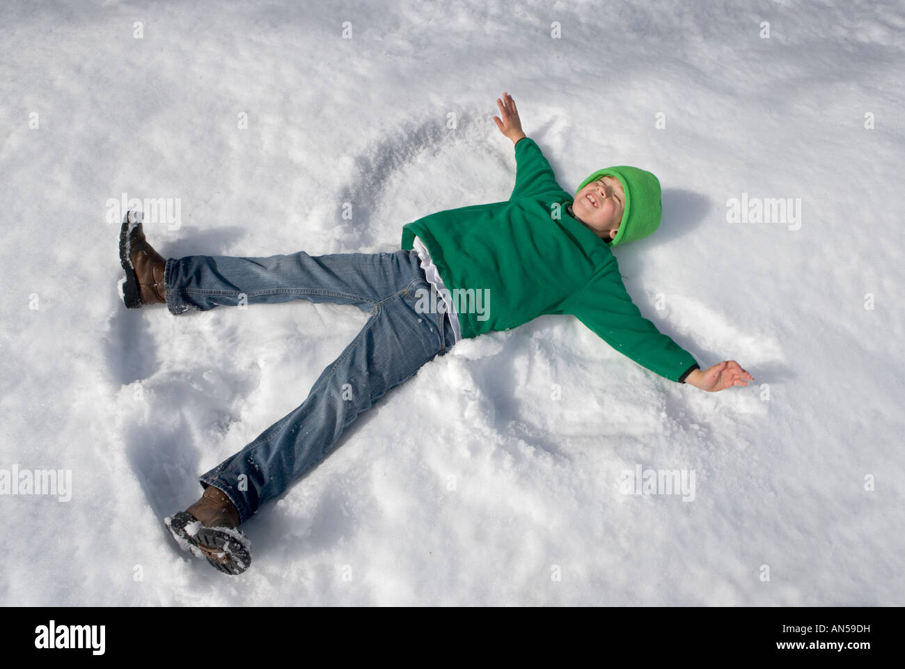 A young boy makes a snow angel Stock Photo - Alamy