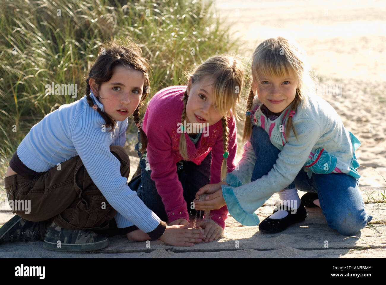 three young friends playing together Stock Photo - Alamy