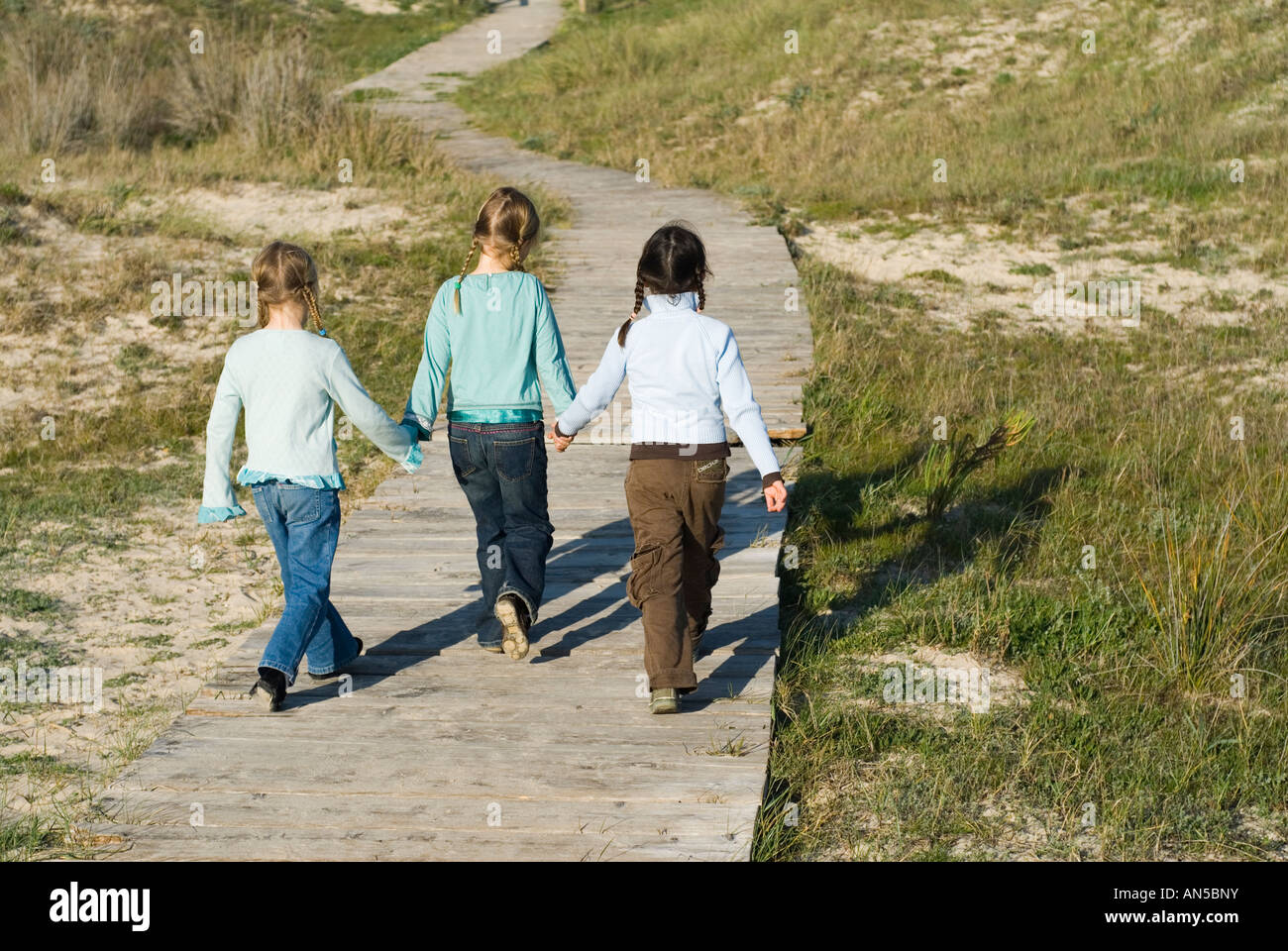 three young friends walking together Stock Photo - Alamy