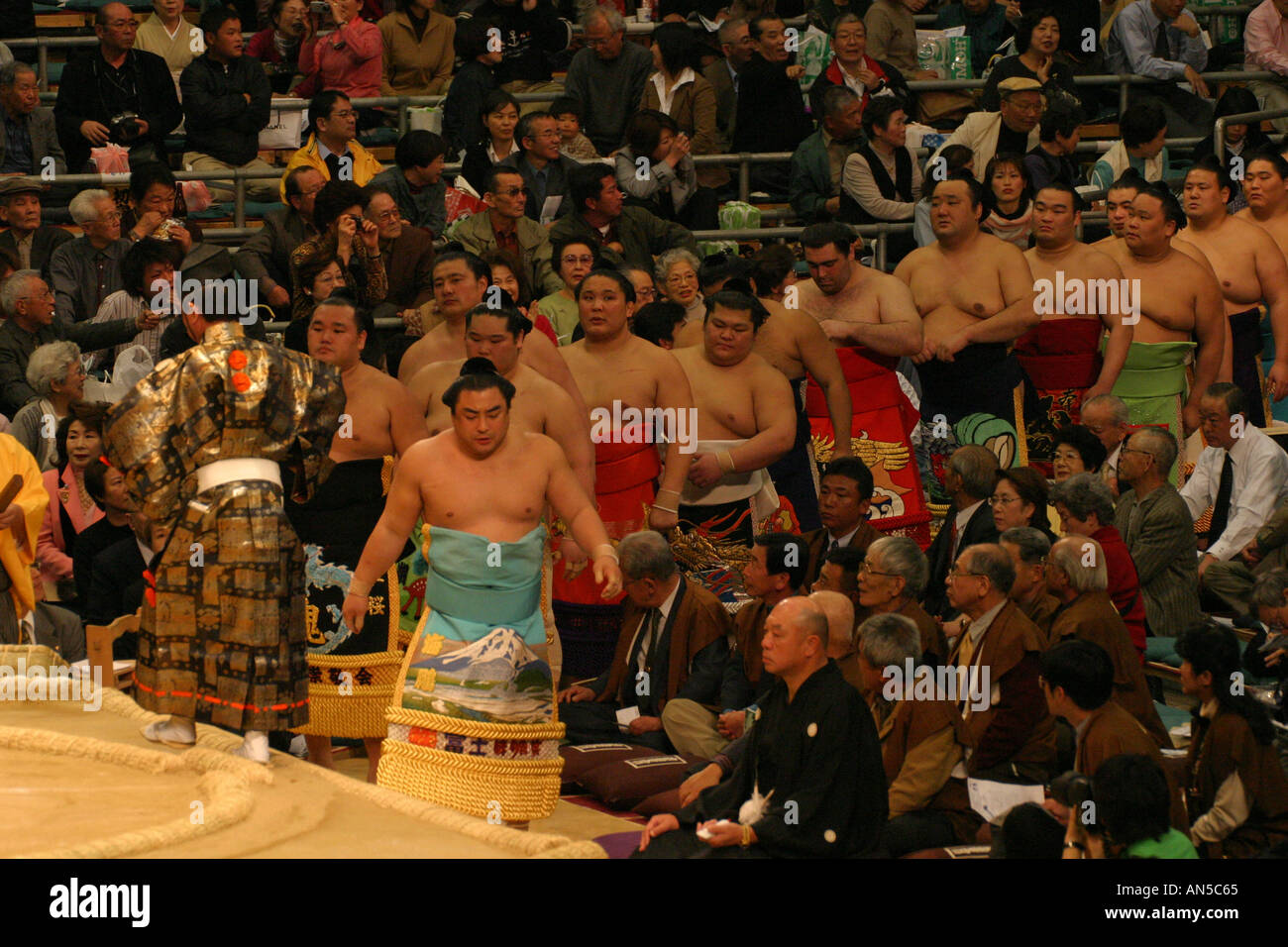 Sumo wrestlers in colourful pre fight silk stable robes enter the ...