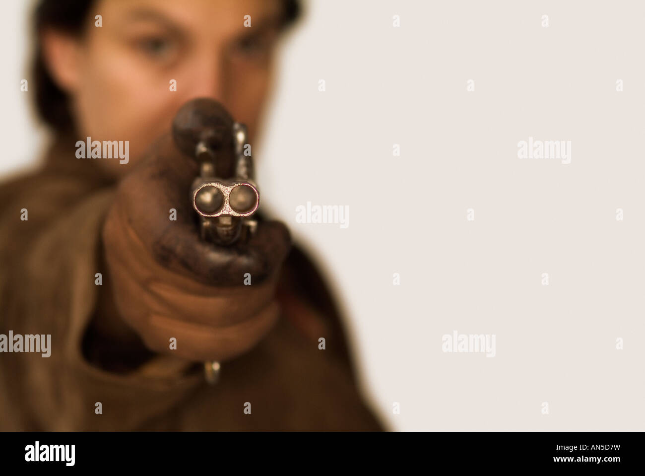 Unrecognizable person aiming to the camera with a double-barreled gun ...