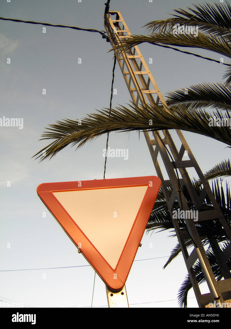 Yield sign and high tension pole Stock Photo - Alamy