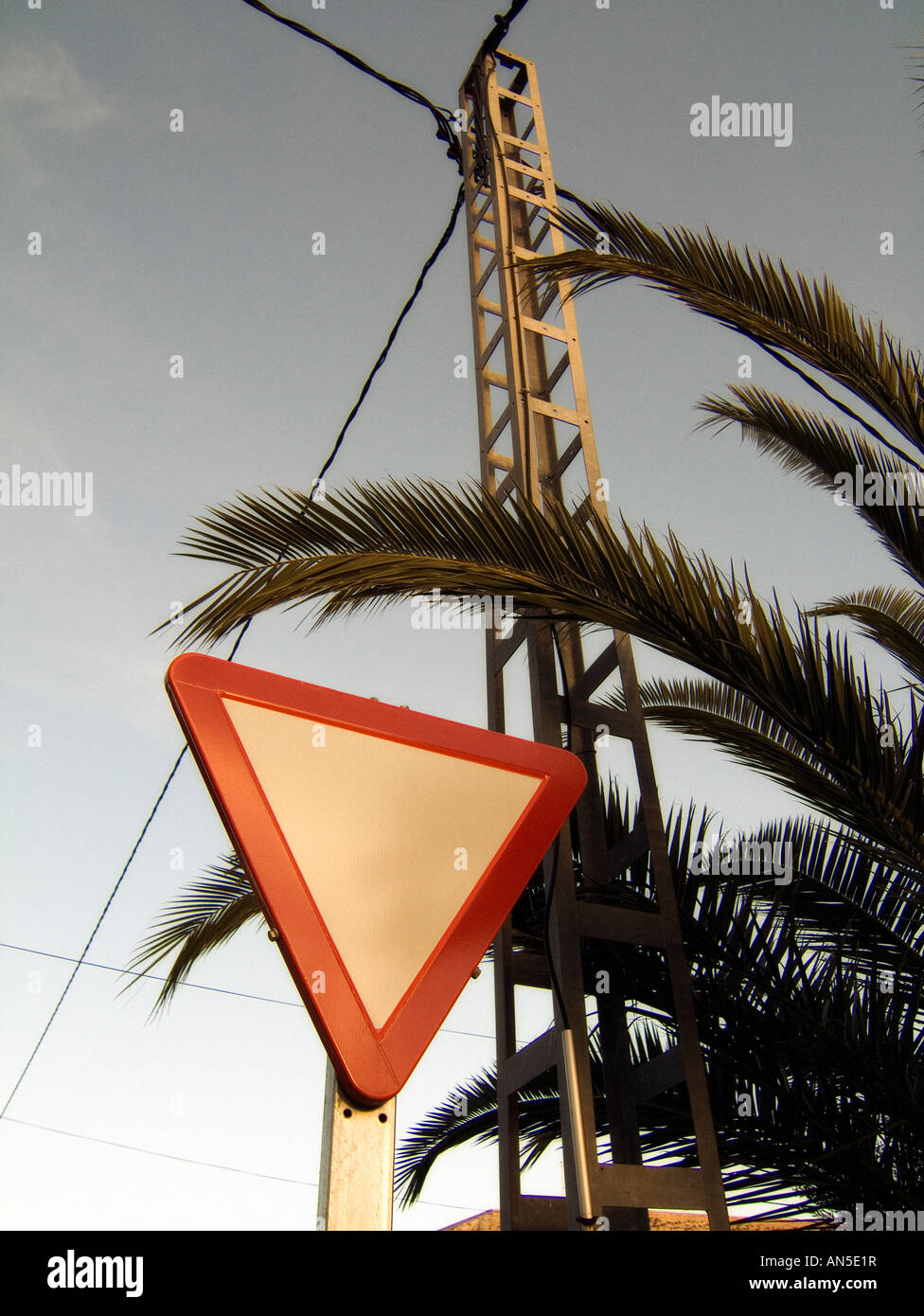 Yield sign and high tension pole Stock Photo - Alamy