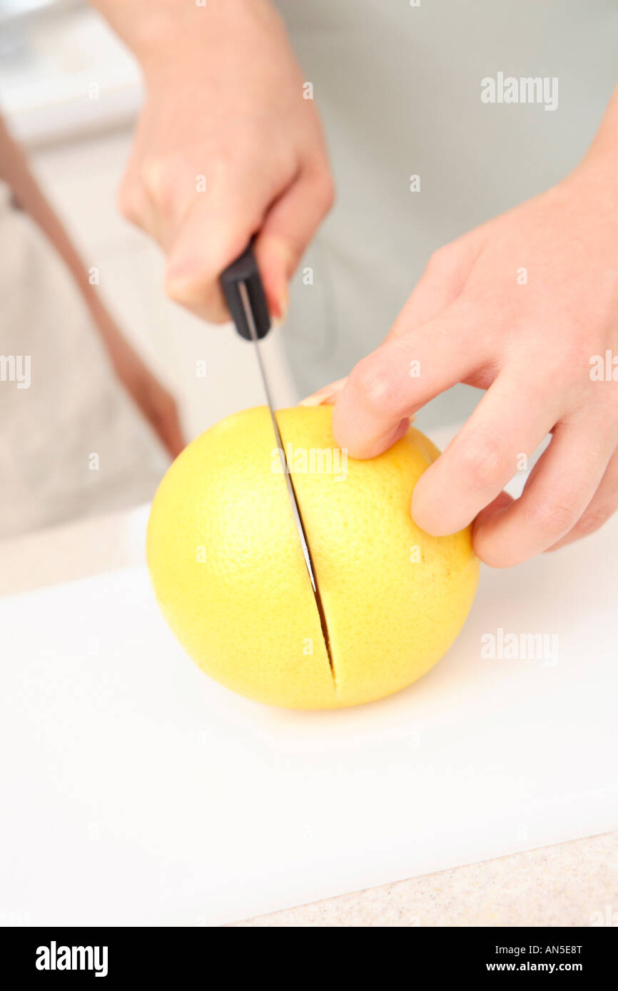 Woman cutting a fruit Stock Photo - Alamy