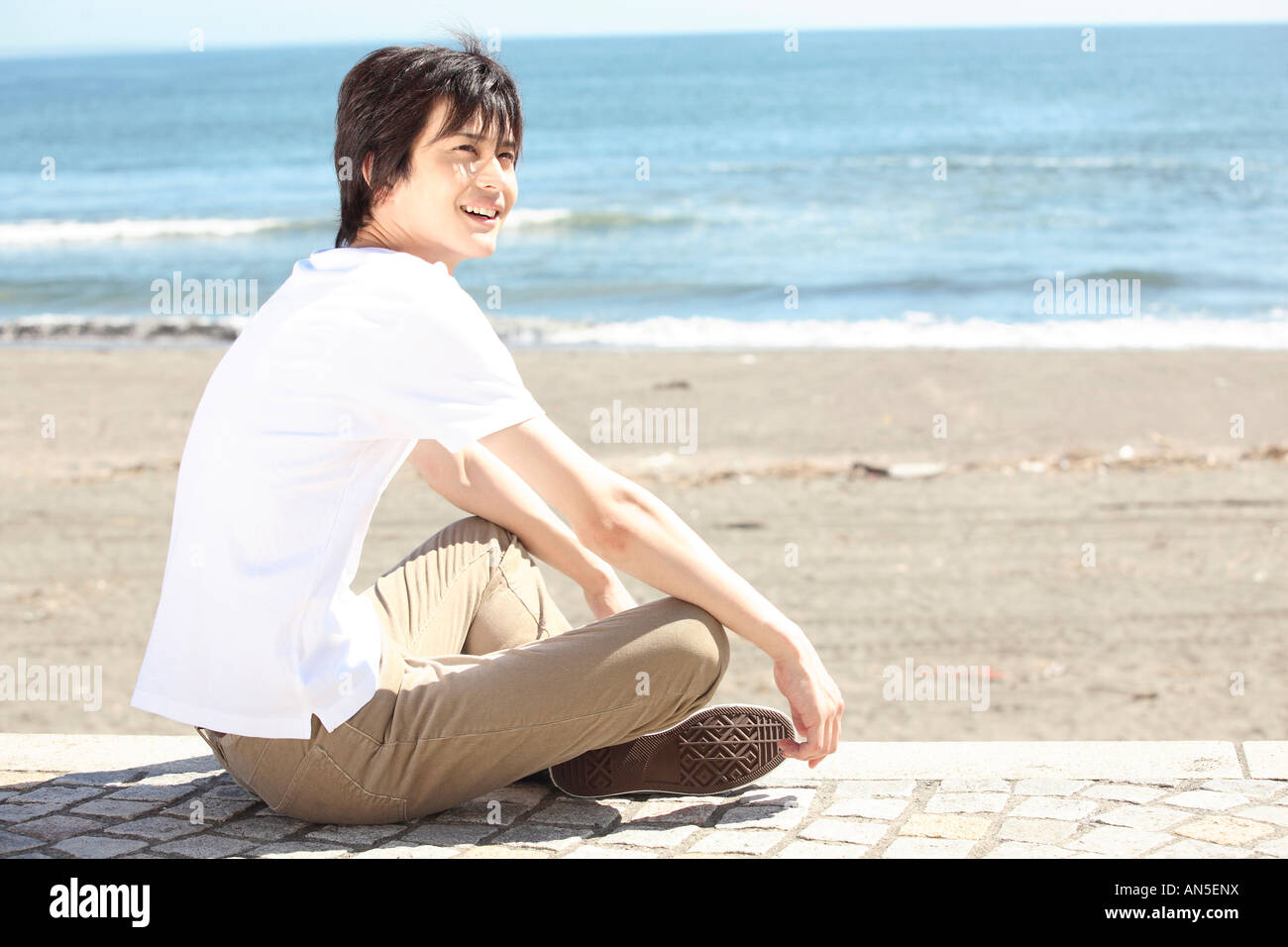 Japanese man sitting on the beach Stock Photo - Alamy