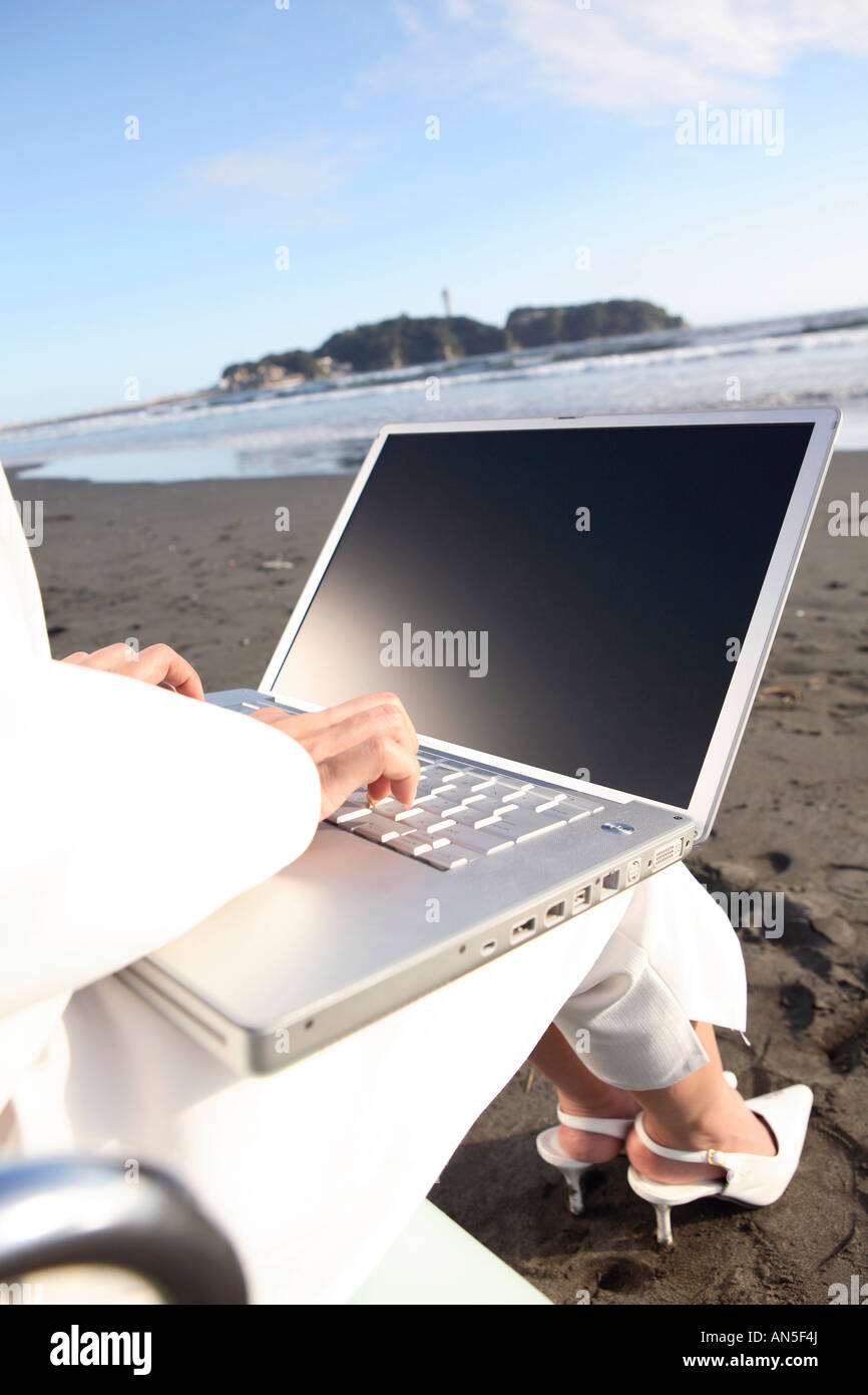 Office lady operating a PC on a beach Stock Photo - Alamy