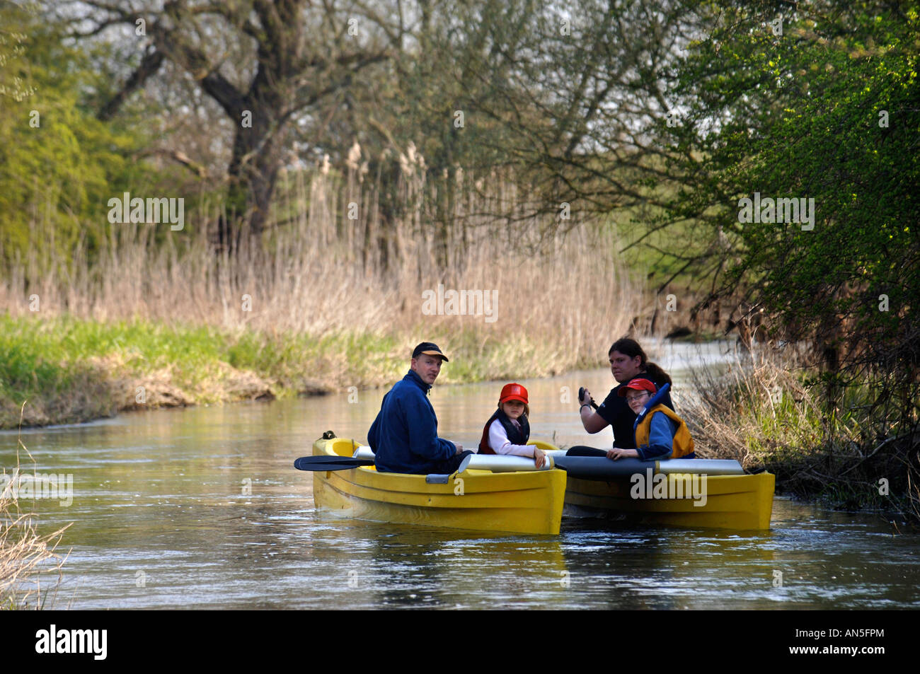A FATHER WITH HIS TWO CHILDREN AND A GUIDE PADDLE DOWN THE RIVER THAMES ...