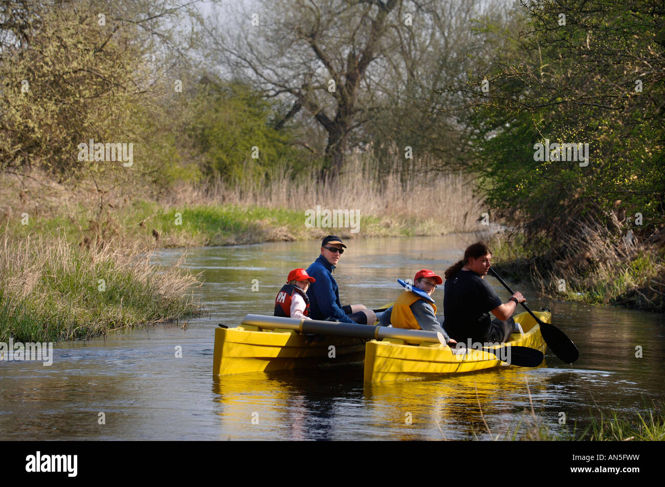 A FATHER WITH HIS TWO CHILDREN AND A GUIDE PADDLE DOWN THE RIVER THAMES ...