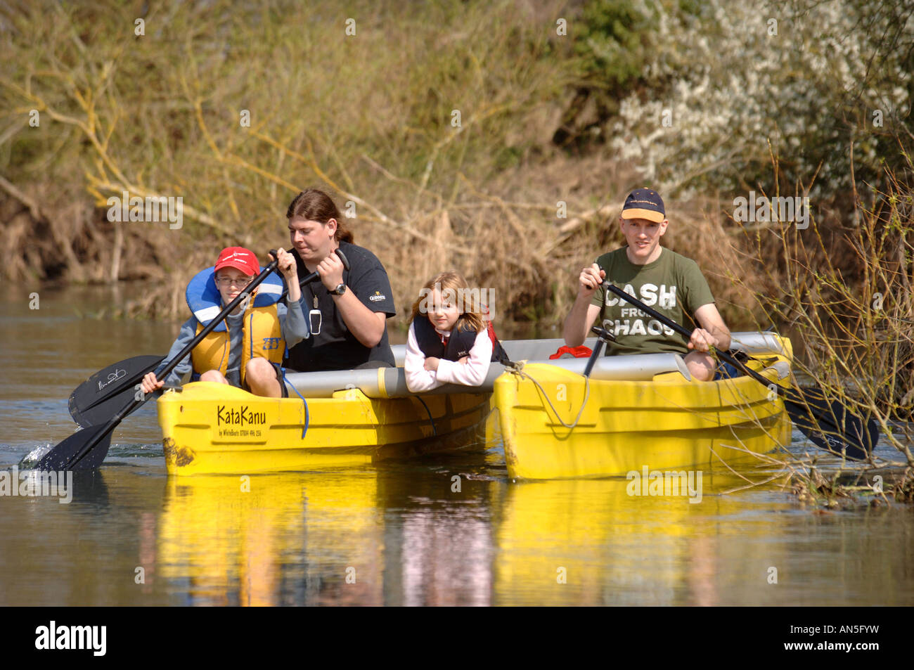 A FATHER WITH HIS TWO CHILDREN AND A GUIDE PADDLE DOWN THE RIVER THAMES ...