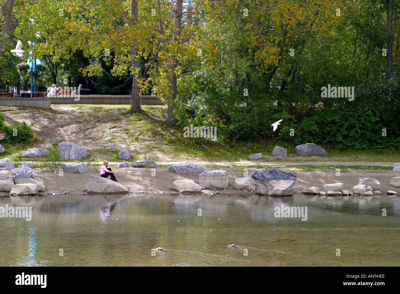 Woman relaxing beside a river Stock Photo - Alamy
