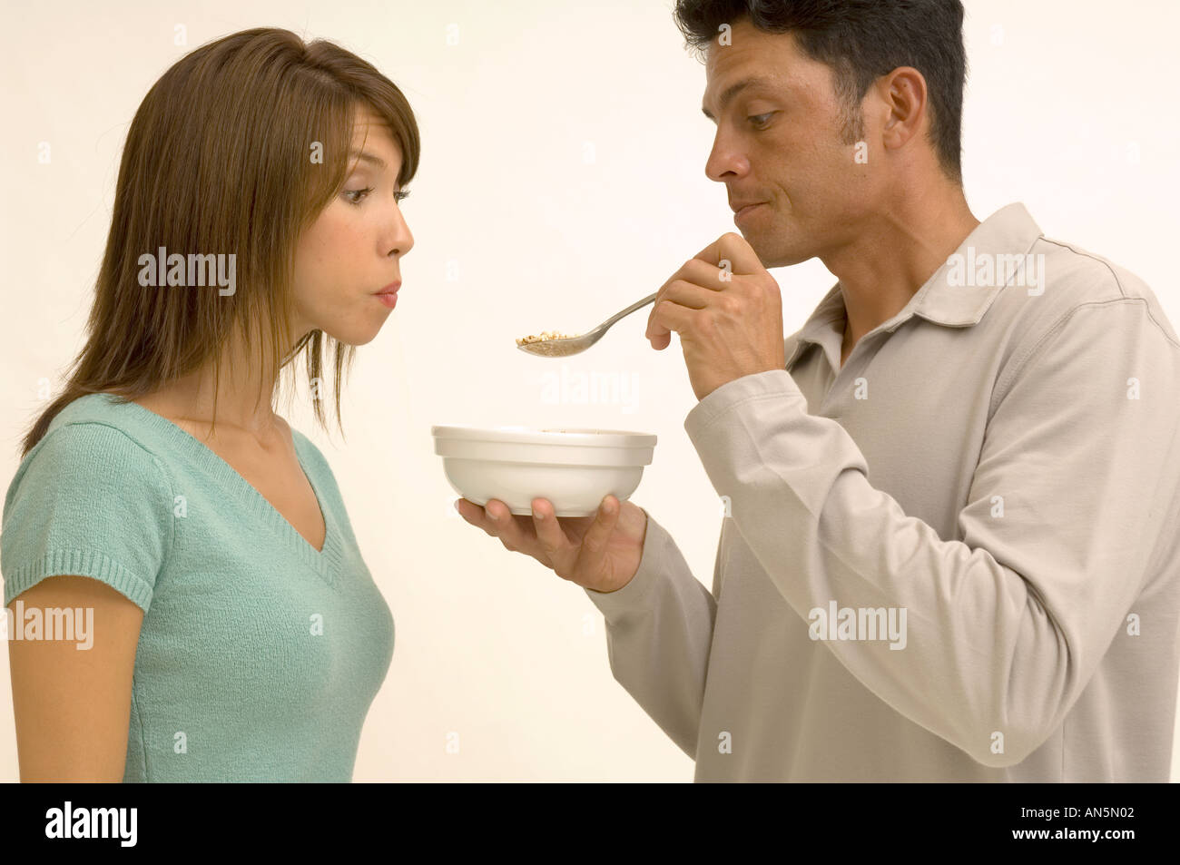 Portrait of a man feeding a woman cereal Stock Photo - Alamy