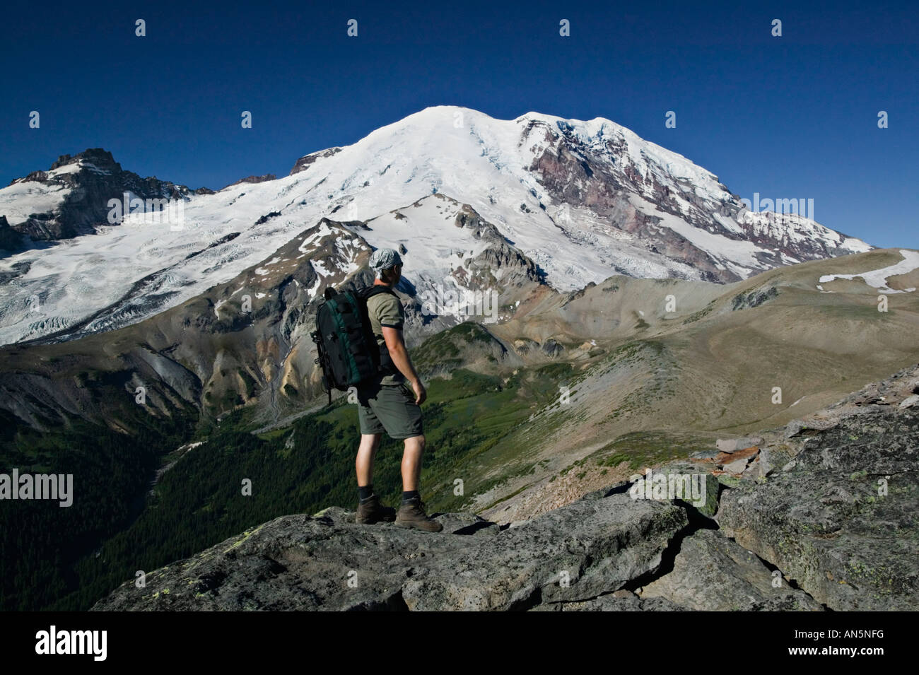 Backpacker and Mt Rainier on sunrise side Stock Photo - Alamy