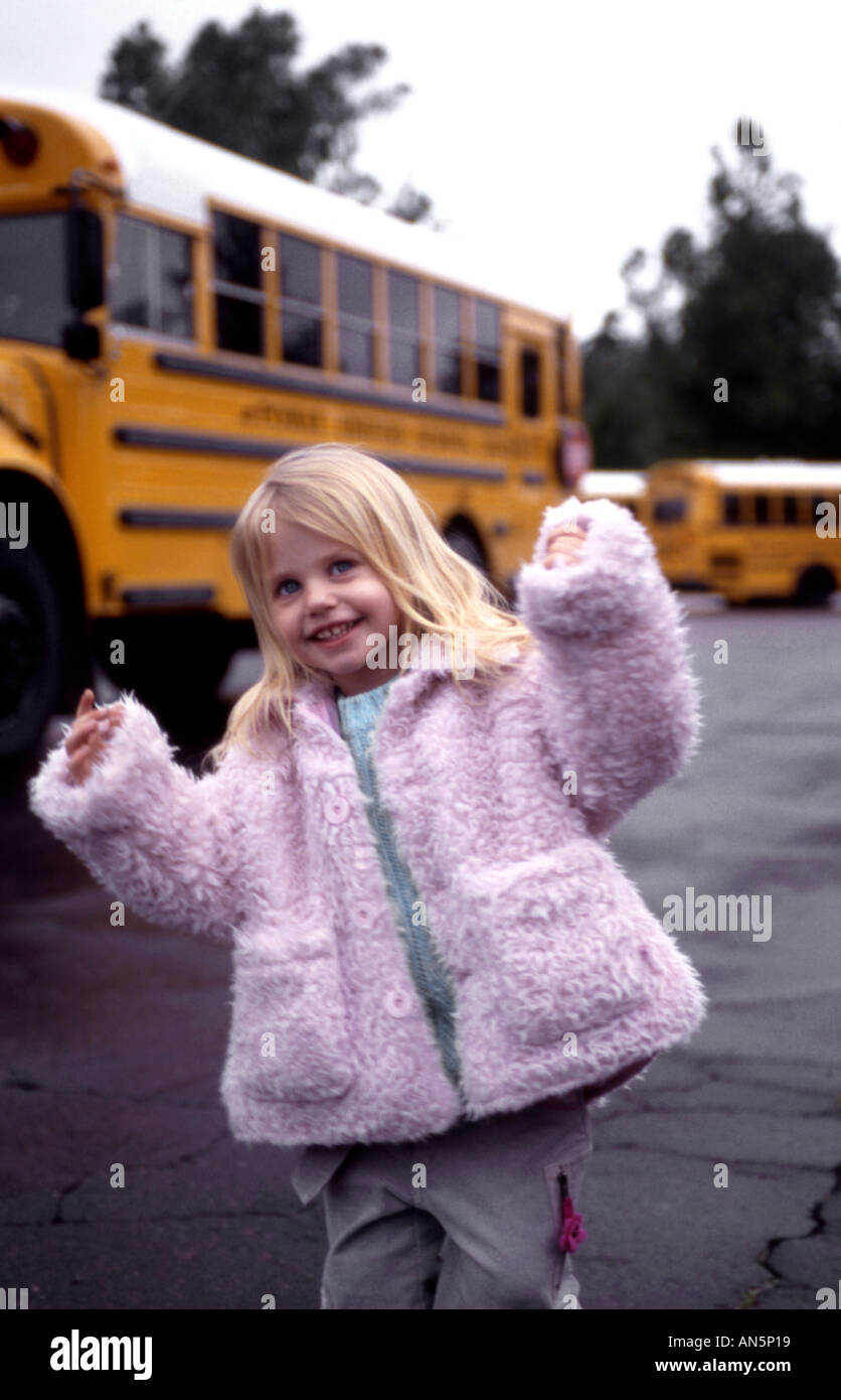 A young girl dances in front of a school bus Stock Photo - Alamy