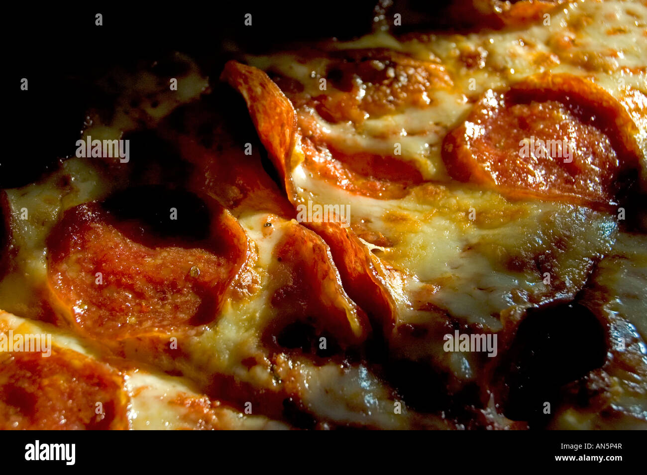 Greasy pepperoni pizza with side light Stock Photo - Alamy